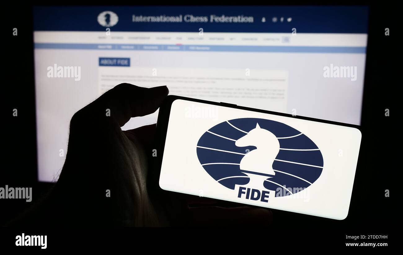 Person holding mobile phone with logo of organisation International ...