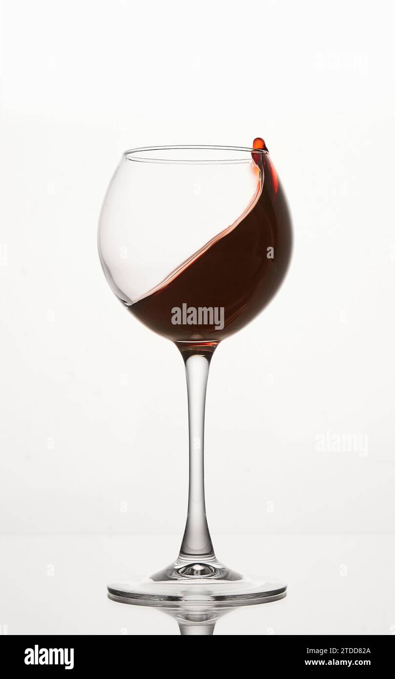 Red wine diagonal wave, curl is in stemmed glass Stock Photo - Alamy