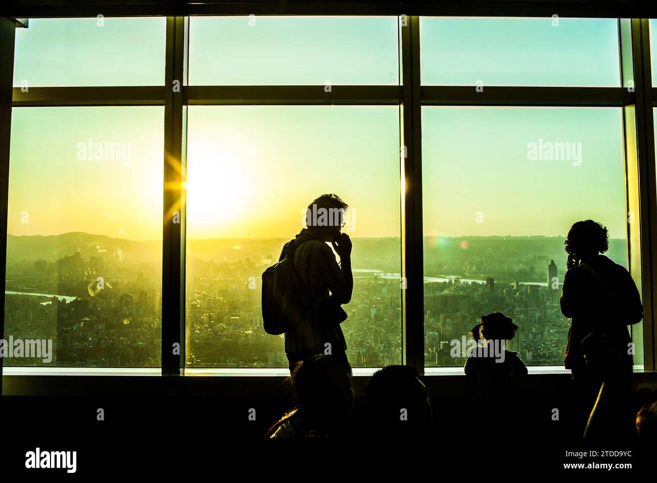Tourists look through the windows at the skyline of Taipei, Taiwan ...