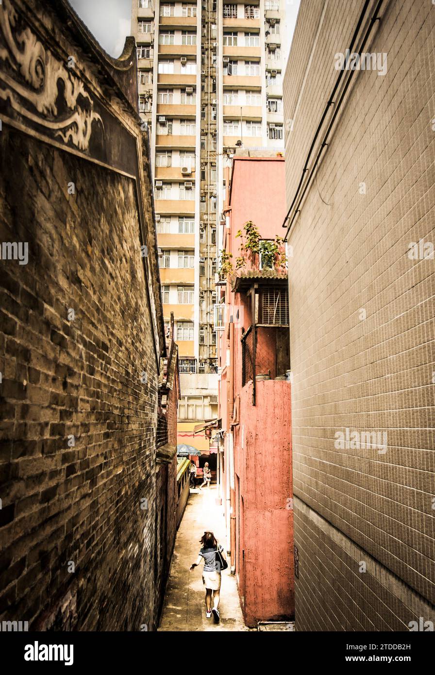 A girl running between a temple and apartment buildings Stock Photo - Alamy