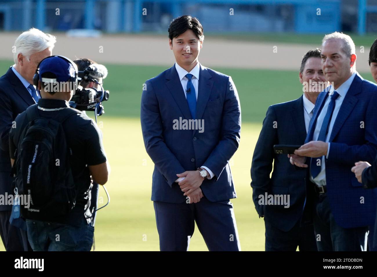 Los Angeles Dodgers' Shohei Ohtani, middle, arrives at a baseball news ...
