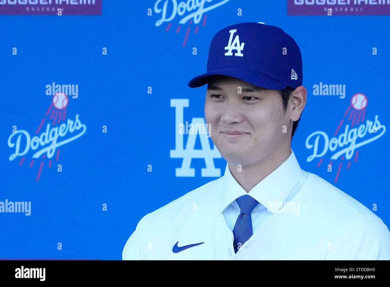 Los Angeles Dodgers' Shohei Ohtani smiles while wearing a jersey and ...