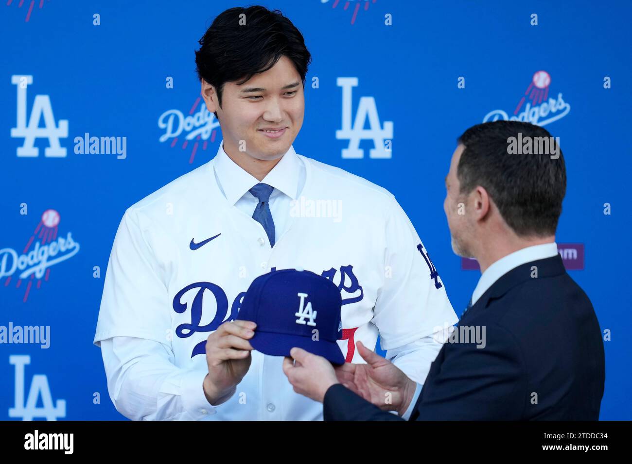 Los Angeles Dodgers' Shohei Ohtani, left, is handed a baseball cap by ...