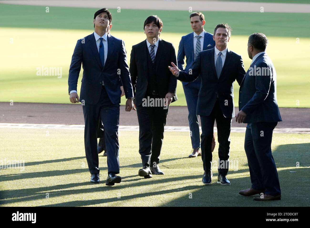 Los Angeles Dodgers' Shohei Ohtani, left, walks to a baseball news ...