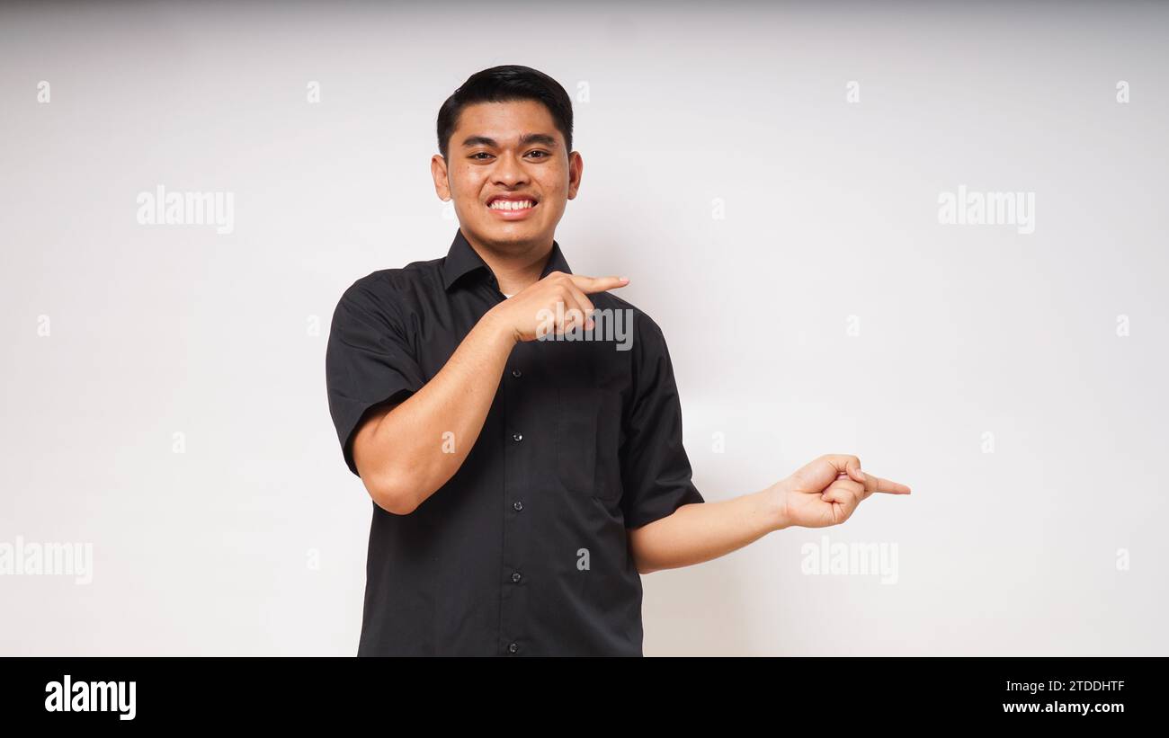 Young Asian man smiling when looking and pointing to the left side on ...