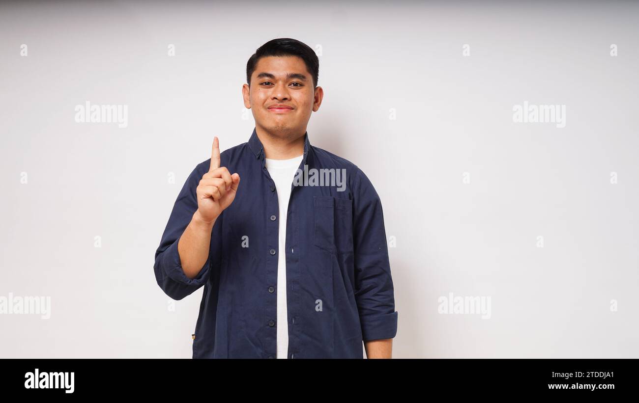 Young Asian man showing happy face expression while giving one fingers ...