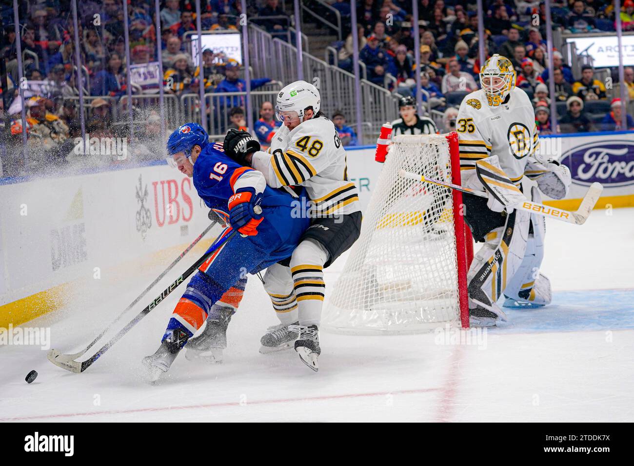 New York Islanders right wing Julien Gauthier (16) is checked by Boston ...