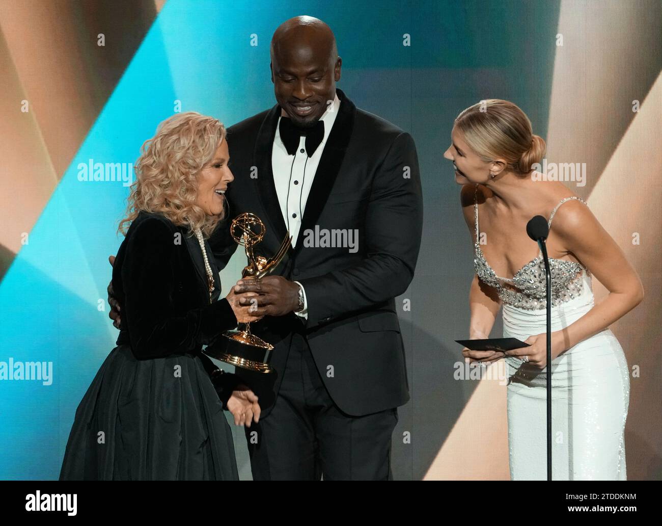 Akbar Gbajabiamila, center, and Amanda Kloots present the award for ...