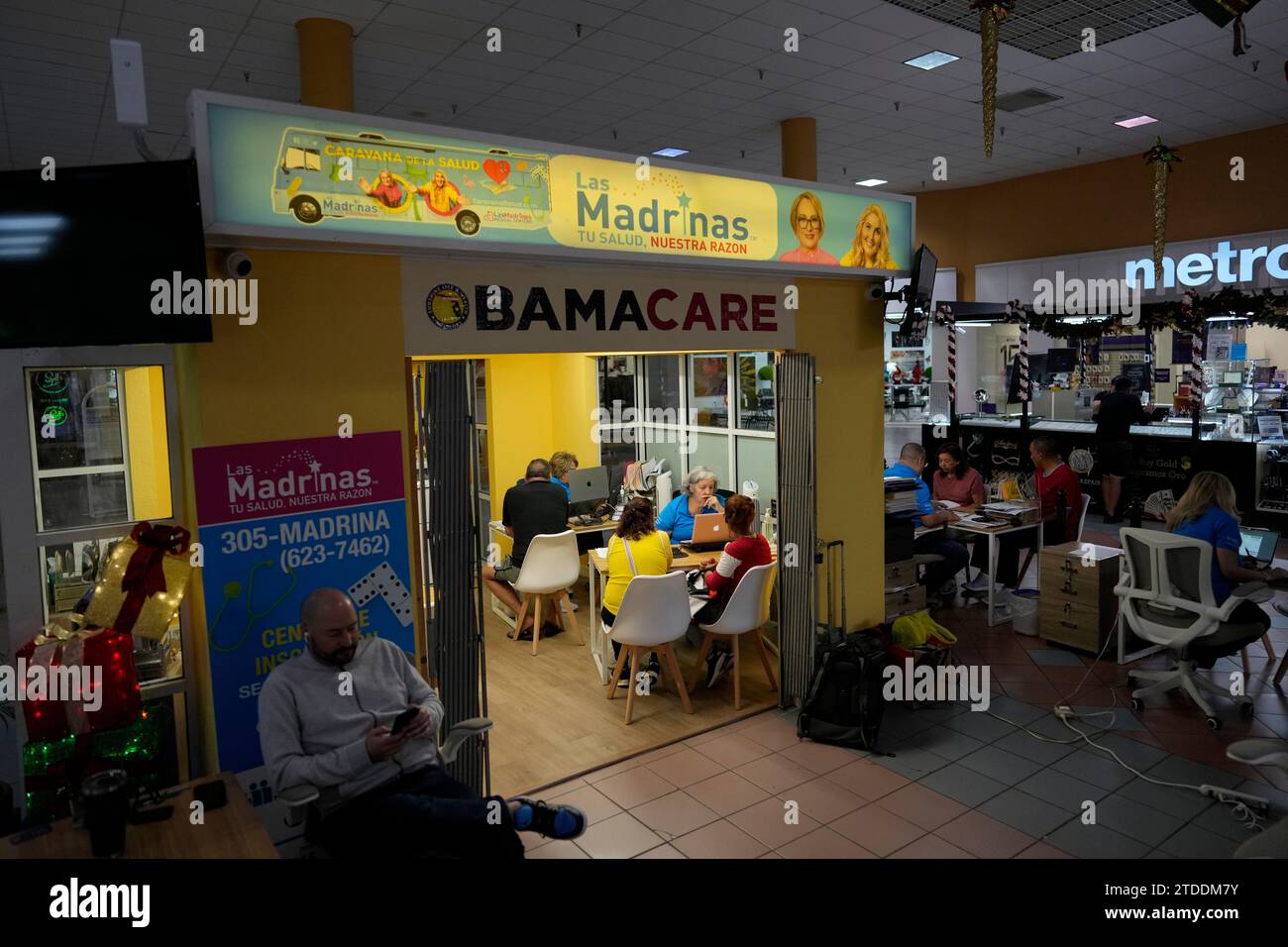 Insurance agent Maria Collado, center, works with clients at a shopping ...