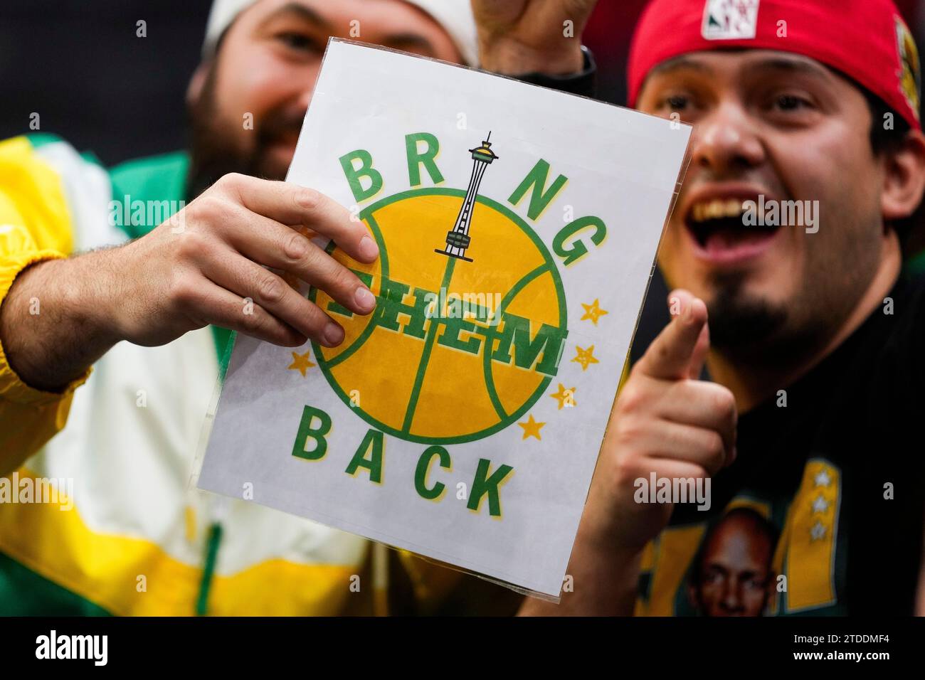 Fans pose for a photo with a sign calling to bring the Seattle ...