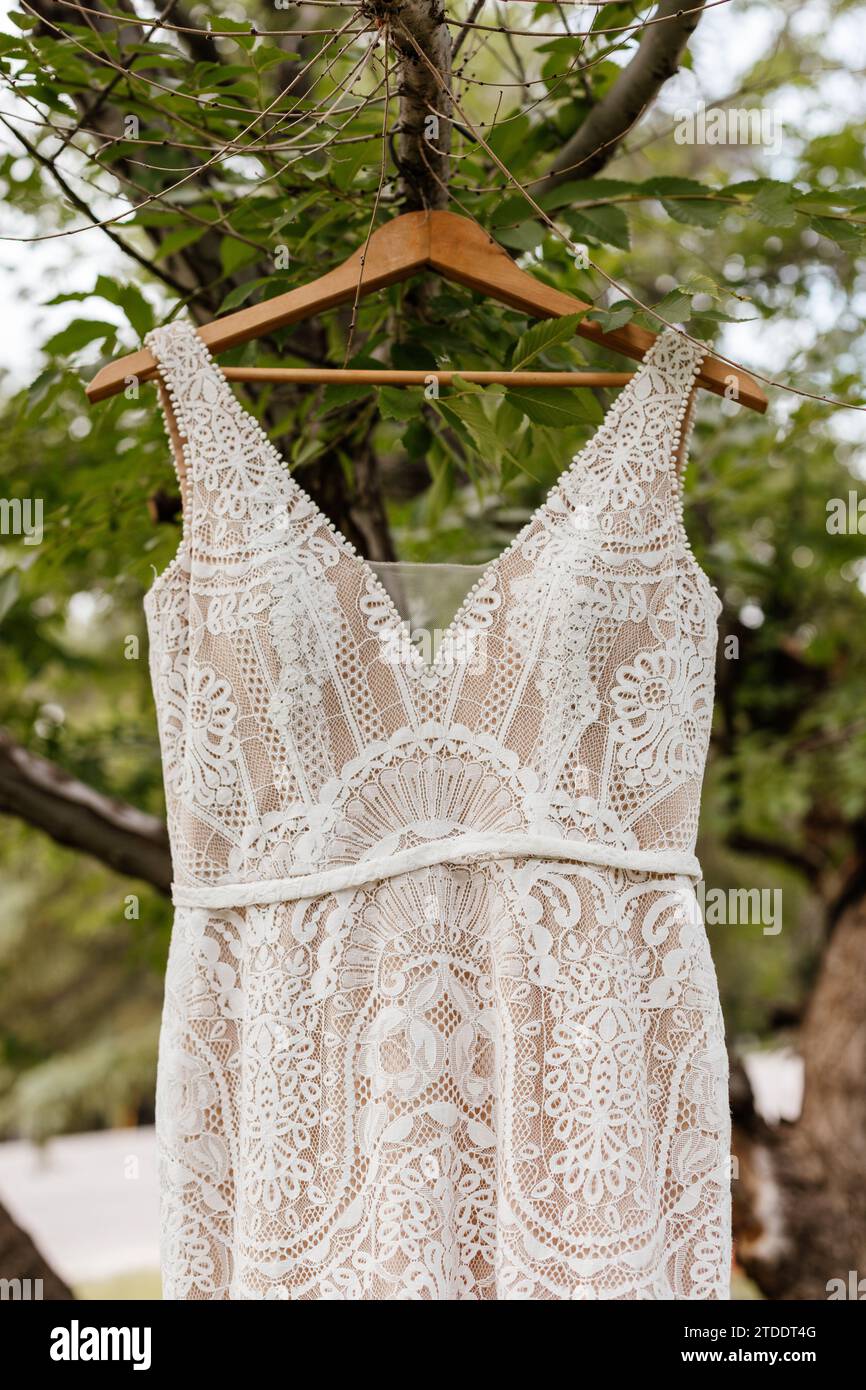 Summer lace wedding dress hanging from a tree Stock Photo - Alamy