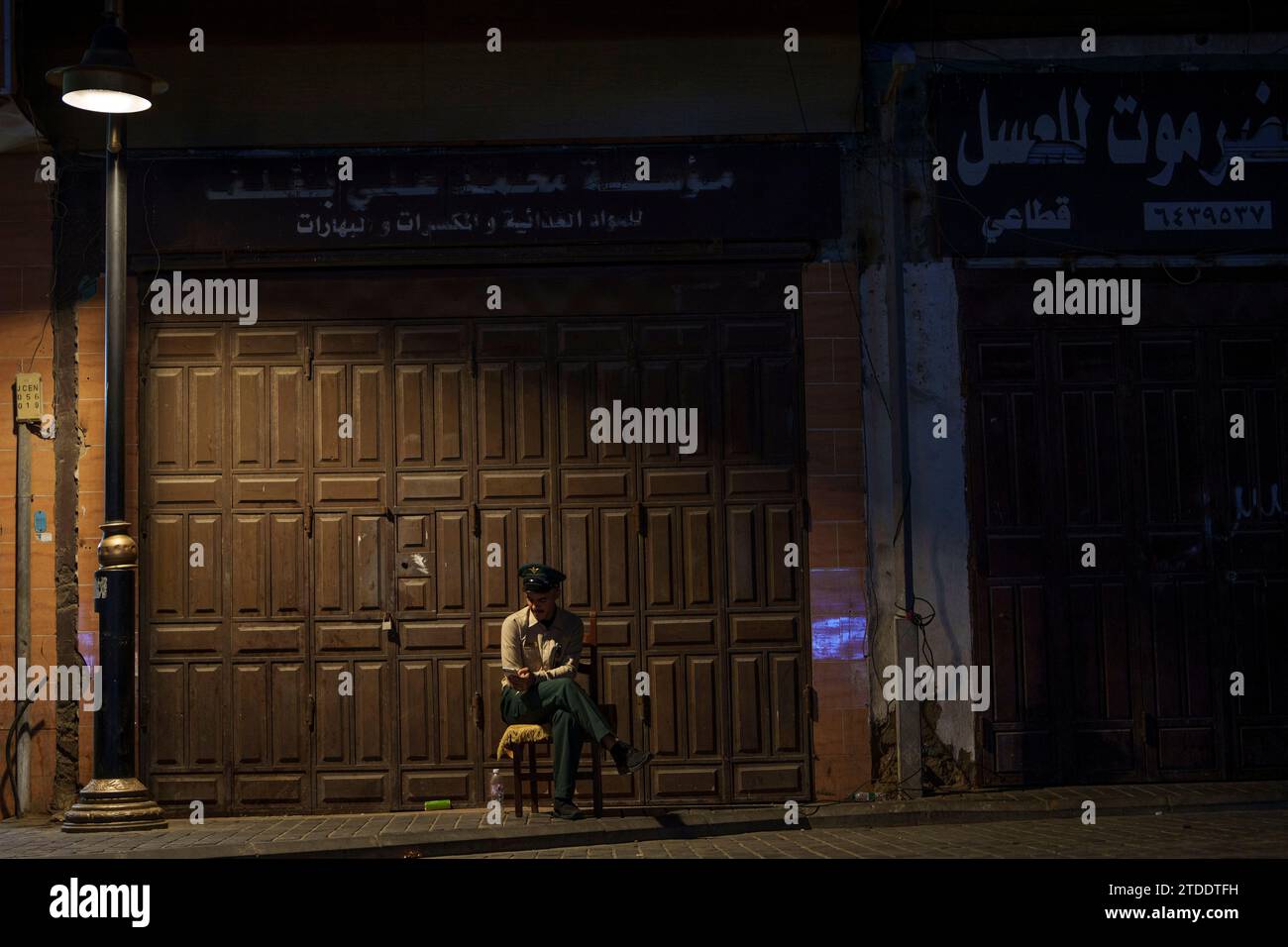A police officer checks his mobile phone in the Al Balad neighborhood ...