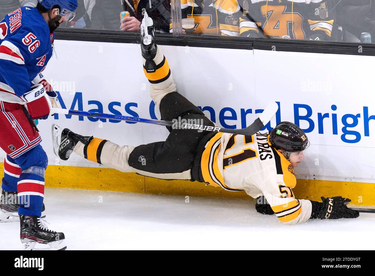 Boston Bruins center Matthew Poitras (51) is tripped up by New York ...