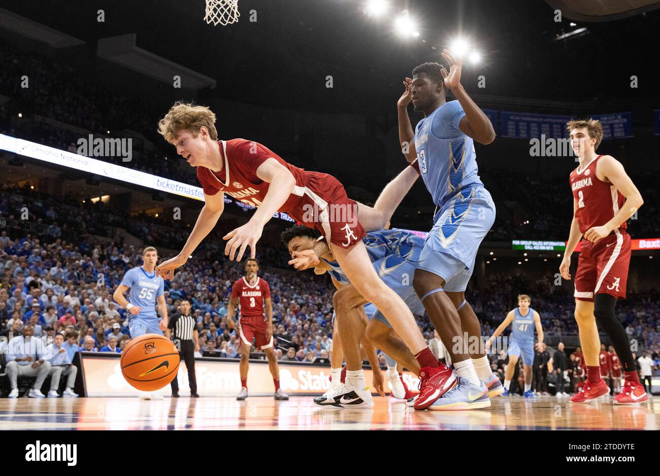Alabama's Sam Walters, from left, falls over Creighton's Trey Alexander ...