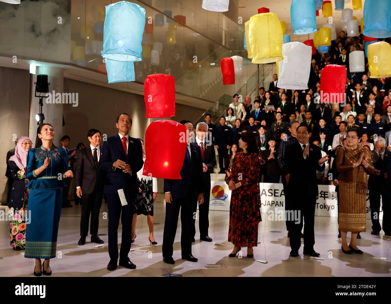 Leaders from ASEAN nations and their spouses release paper lanterns into the air with students ...