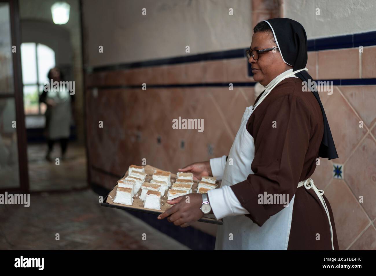 Nun Veronicah Nzula, 47, from Kenya, carries cakes after taking them ...