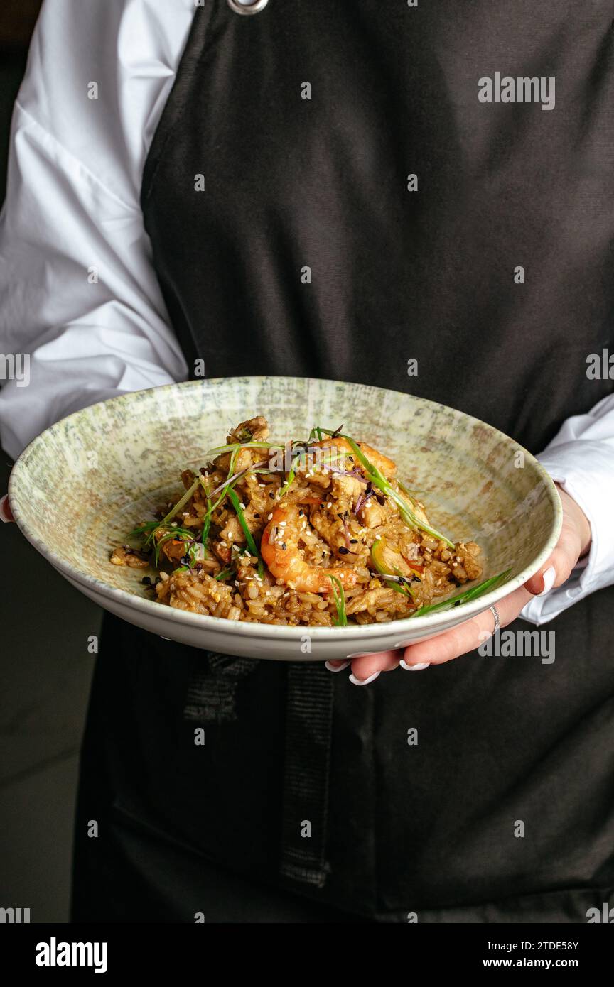 The waiter holds a plate of fried Chinese rice Stock Photo - Alamy