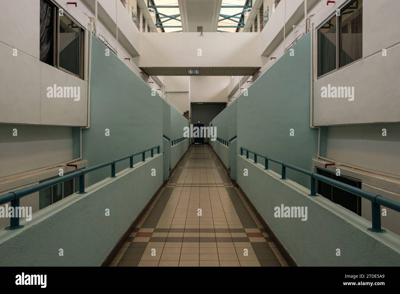 An open apartment walkway with railings on both sides, featuring a ...