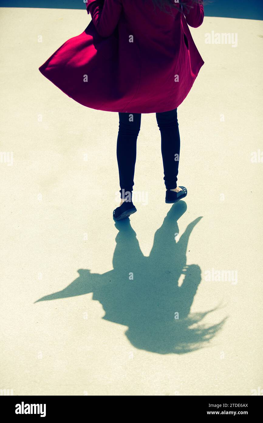 Close up of woman in red coat running away Stock Photo - Alamy