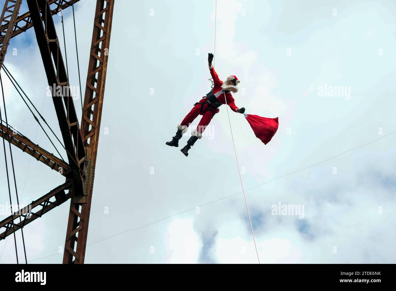 Firefighter Hector Chacon, dressed as Santa Claus, rappels down to give ...