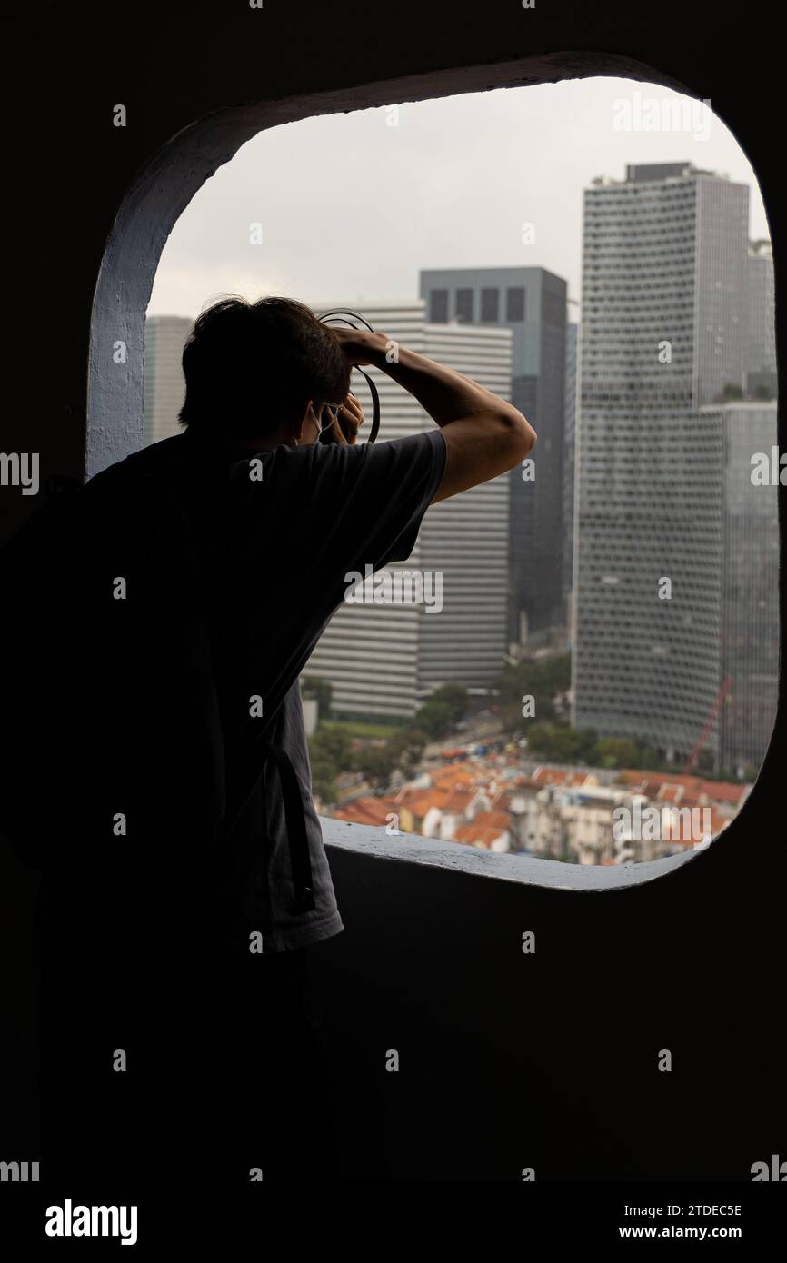 Young Photographer Frames Cityscape Through Window Stock Photo - Alamy