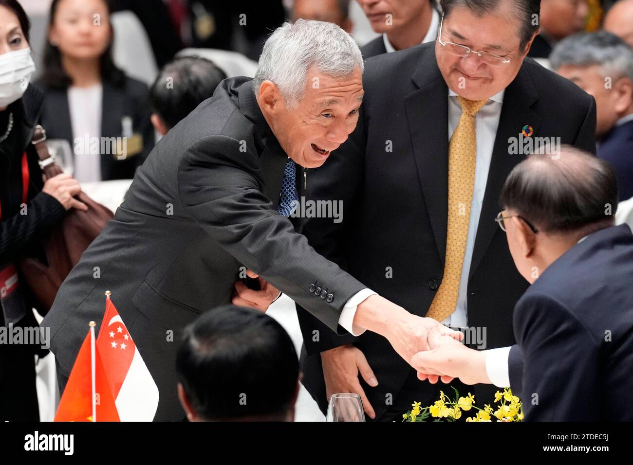 Singapore's Prime Minister Lee Hsien Loong, left, shakes hand with one ...