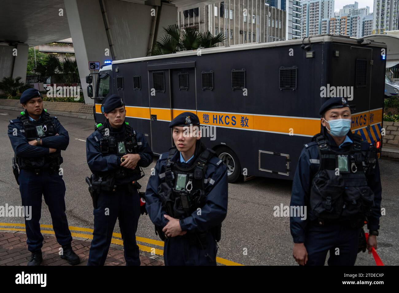 Police officers stand guard as an armored prison van carrying activist ...