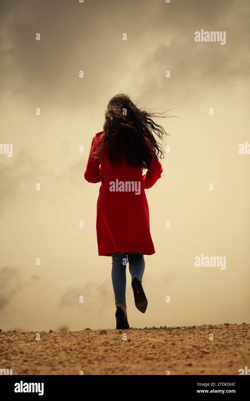 Rear view of woman running away at sunset Stock Photo - Alamy