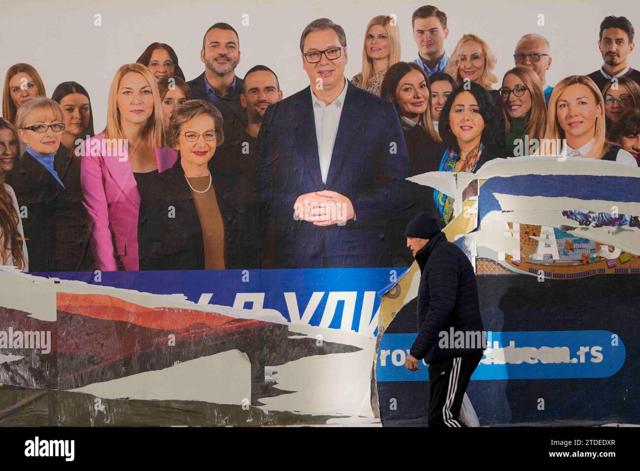 A man walks past a damaged pre-election billboard showing Serbian ...