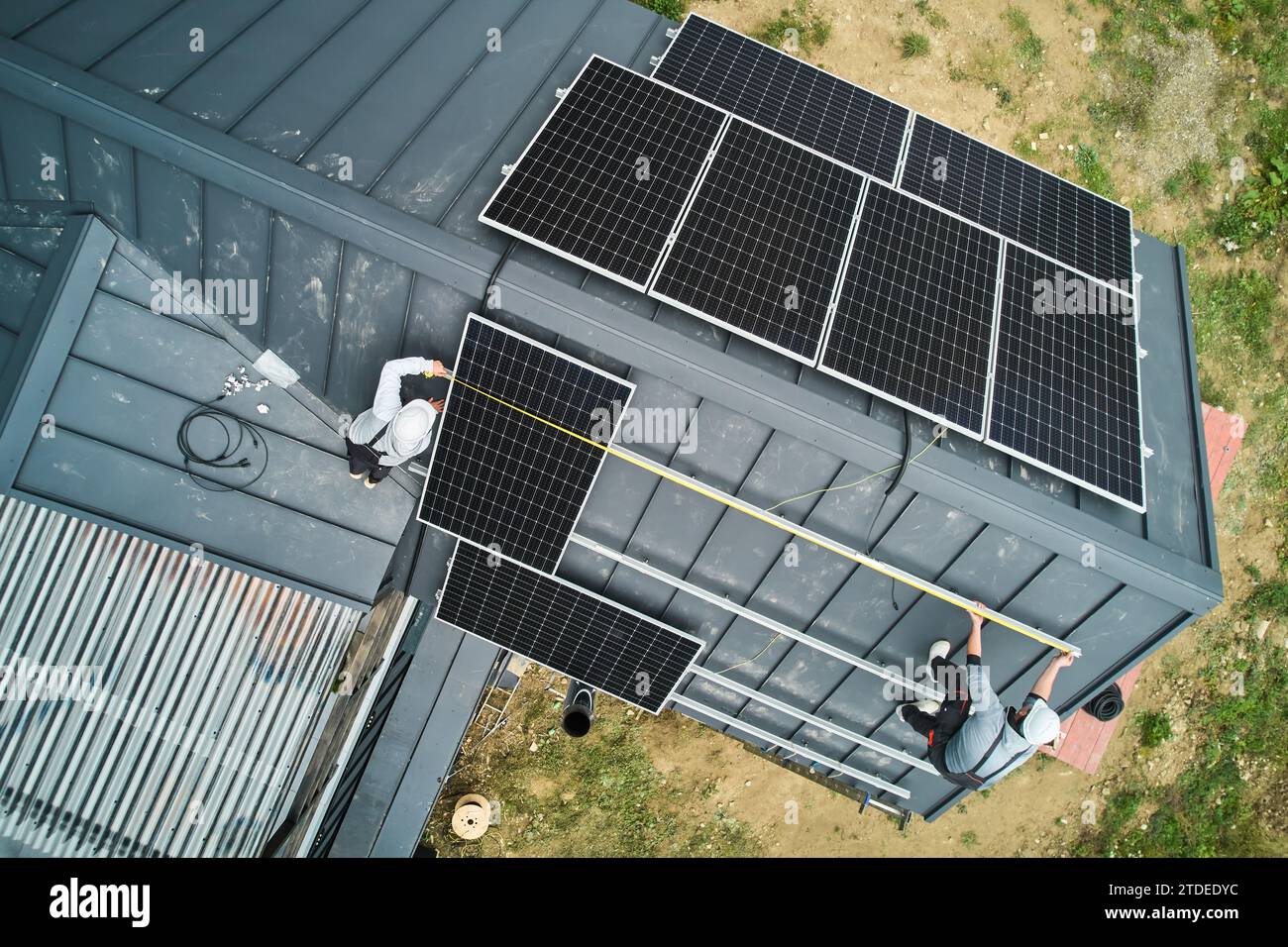 Technicians measuring photovoltaic solar panels with tape measure ...