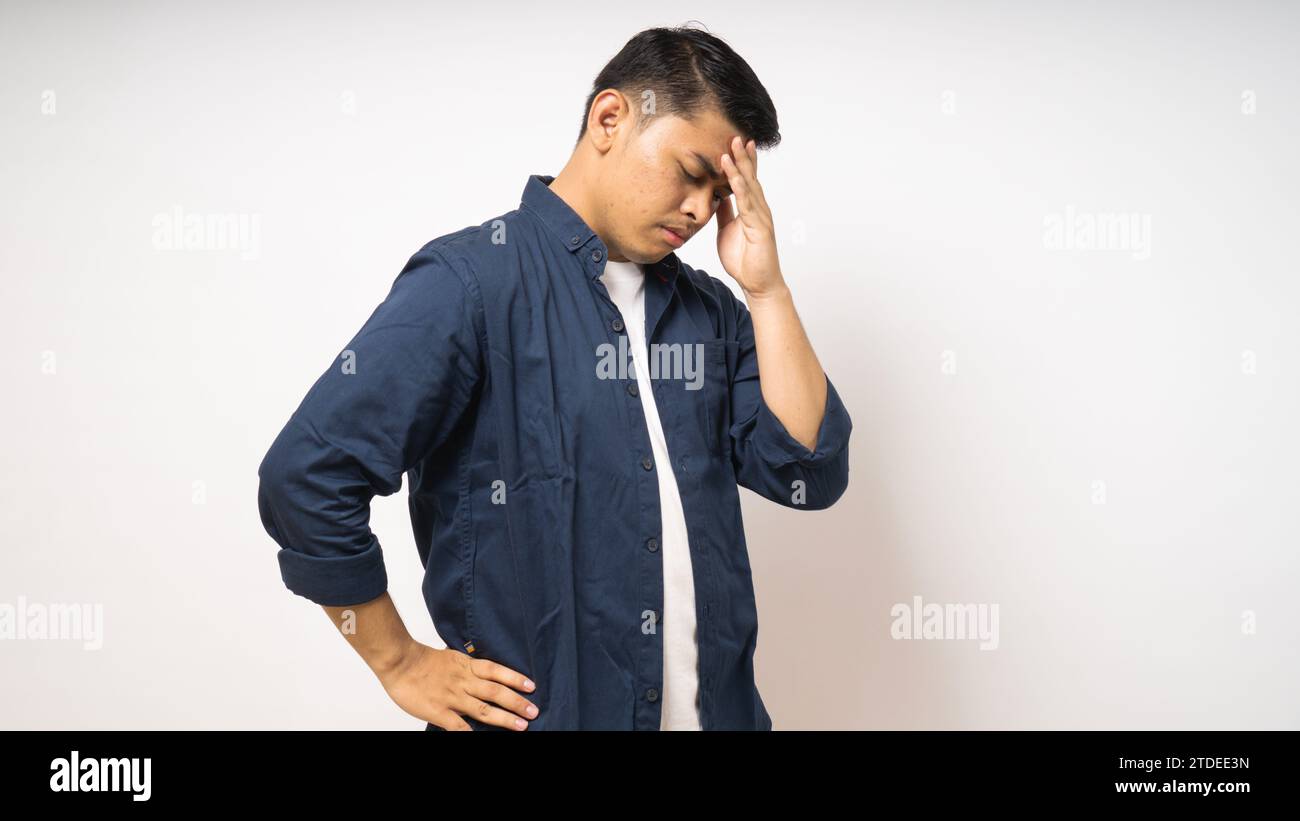 Asian young man showing in pain expression while touching his head ...