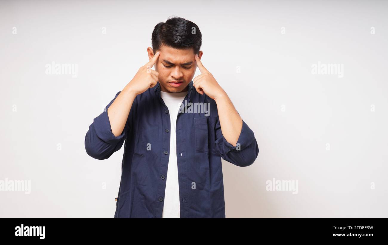 Asian young man showing in pain expression while touching his head ...
