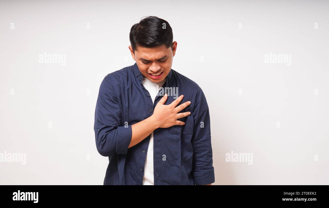 Young Asian man touching his chest with pain expression. Heart attack ...