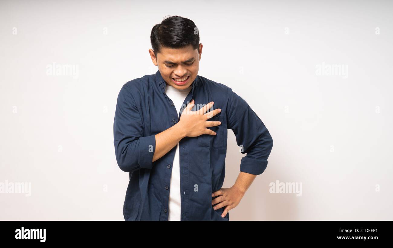 Young Asian man touching his chest with pain expression. Heart attack ...