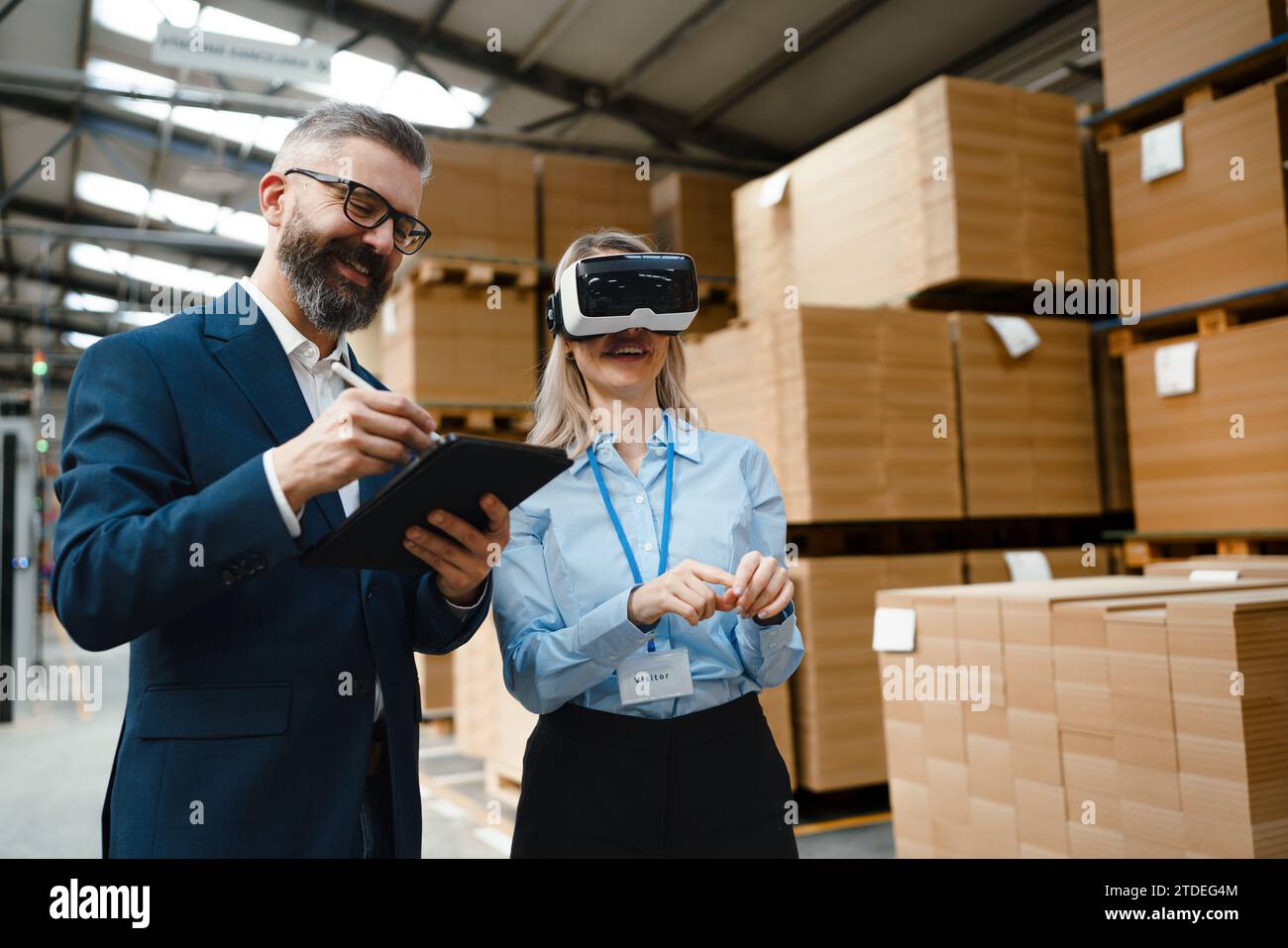 Warehouse managers talking logistics using VR, controlling stock levels ...