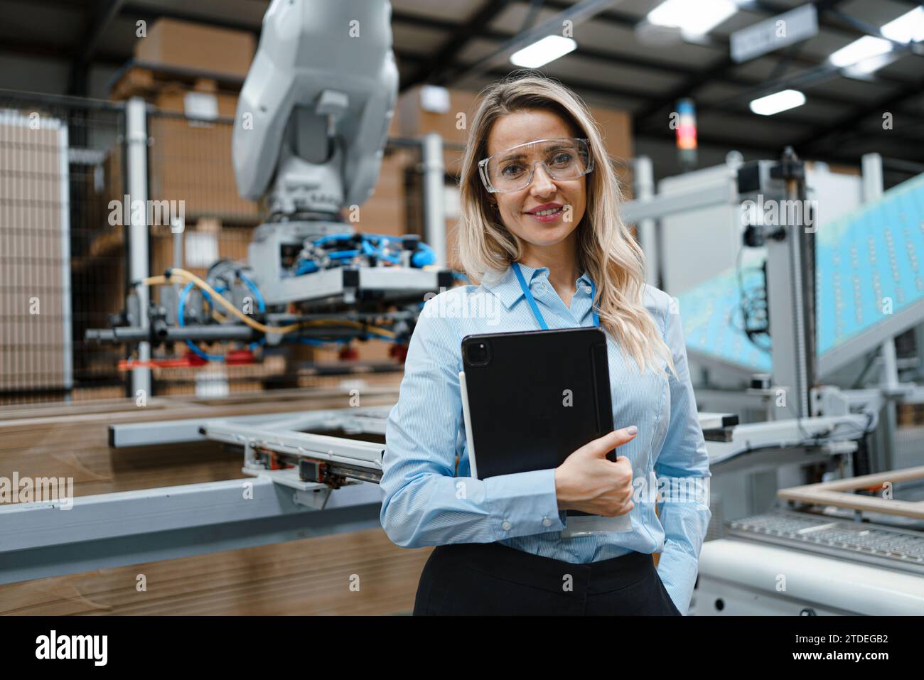 Female manager standing in modern industrial factory. Manufacturing ...