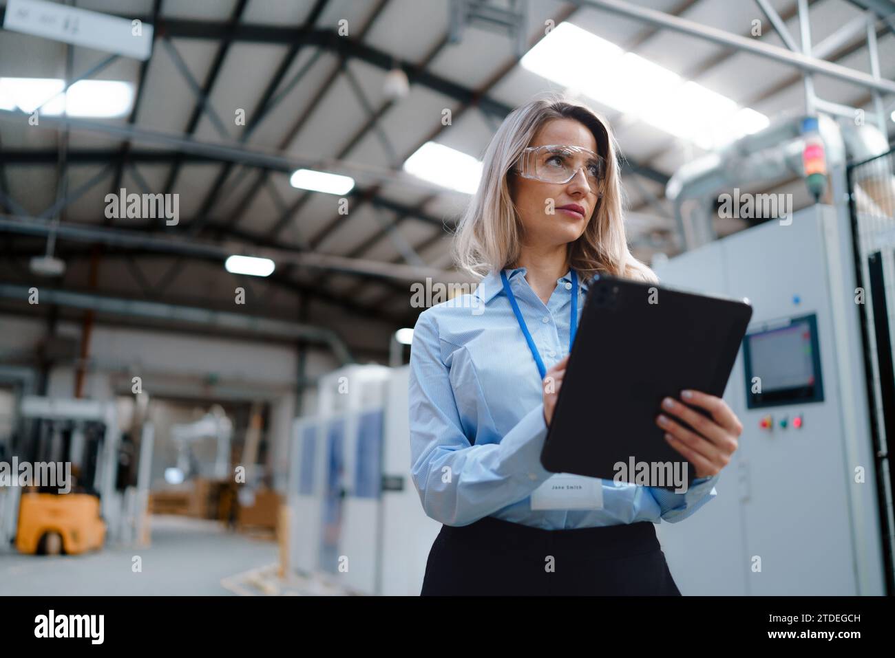 Female manager standing in modern industrial factory. Manufacturing ...