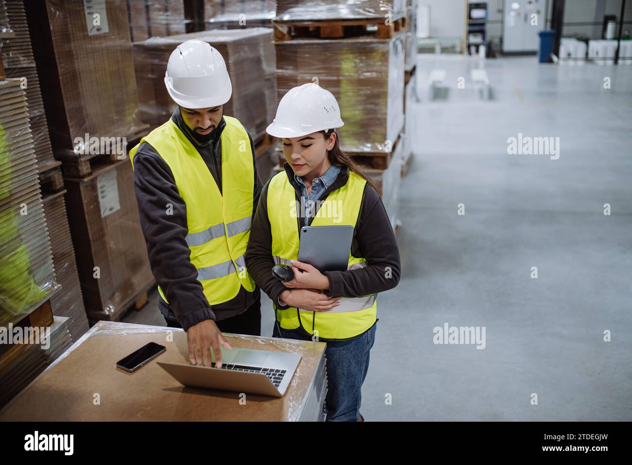 Warehouse manager talking with logistics employee in warehouse ...