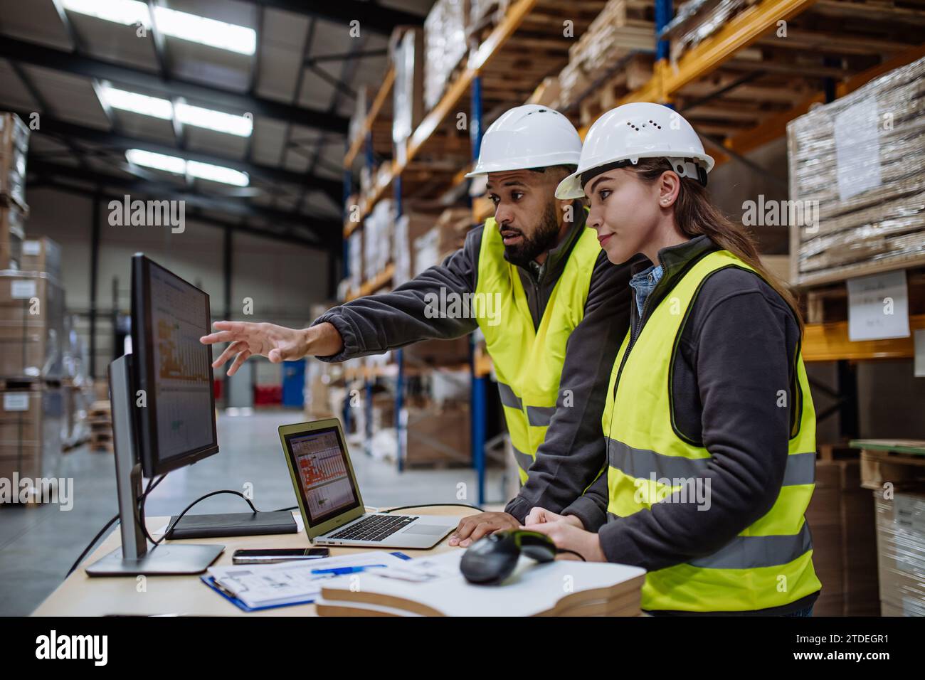 Warehouse manager talking with logistics employee in warehouse ...