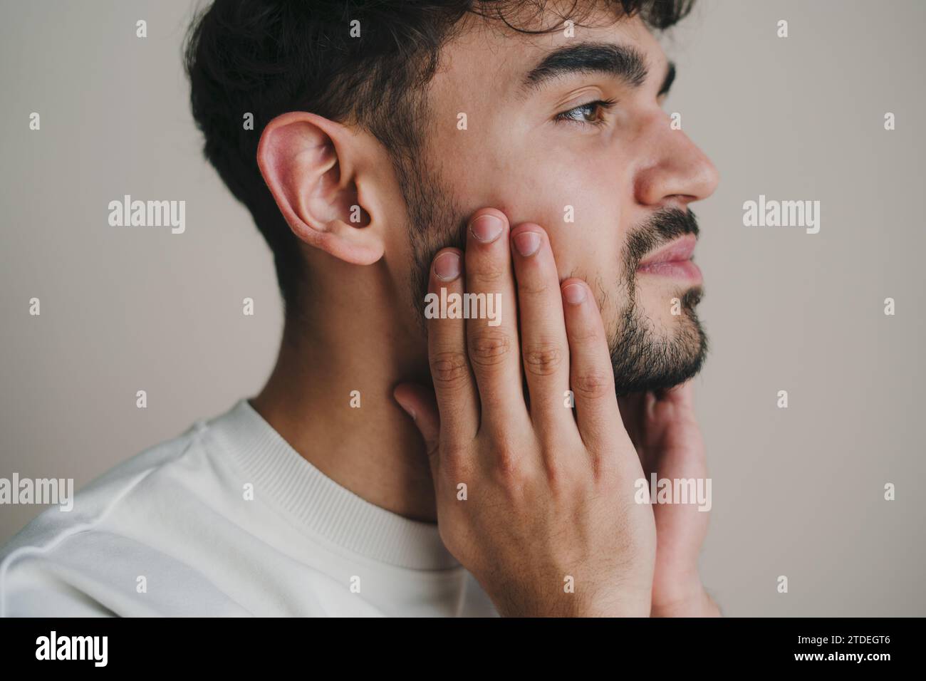 Side view portrait of an attractive, modern, confident, man touching ...