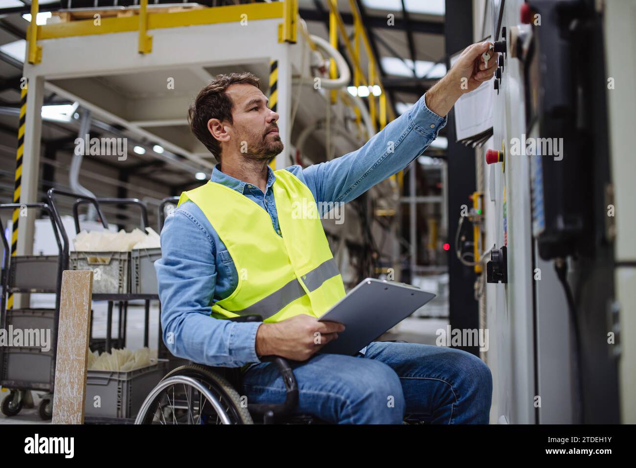 Portrait of man in wheelchair working in modern industrial factory, in ...