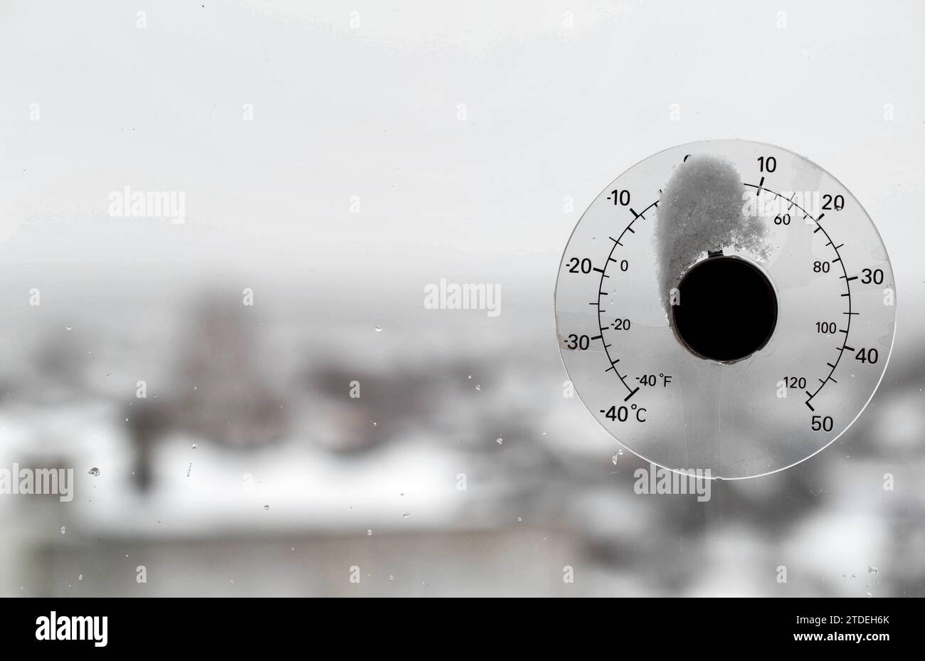 Window outdoor thermometer on glass in cloudy weather and snow cap ...
