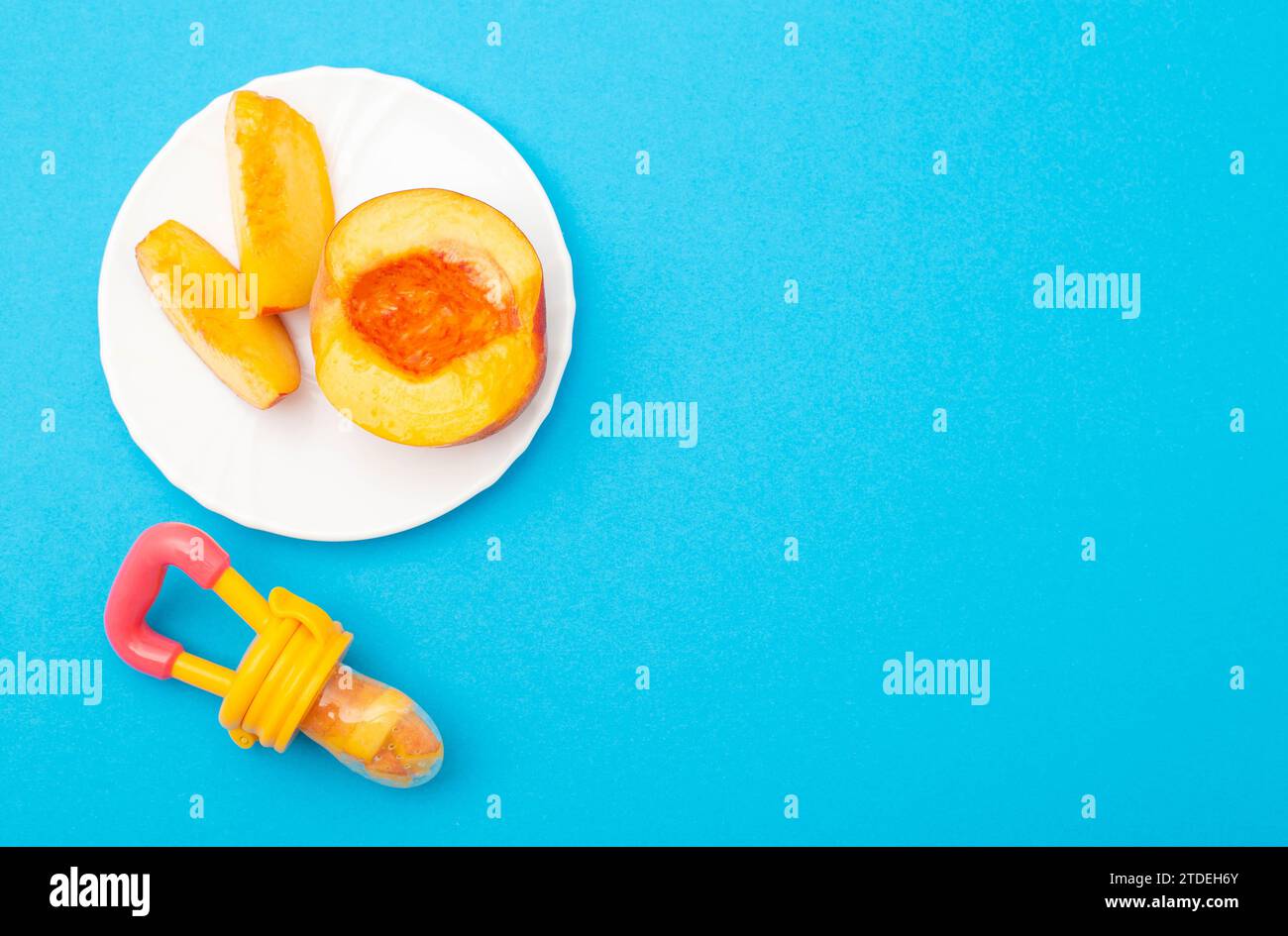 Nibbler for children and a plate with peach on a blue background ...