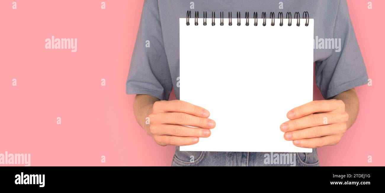 Banner with female hands hold square notepad. Blank mockup in front of ...