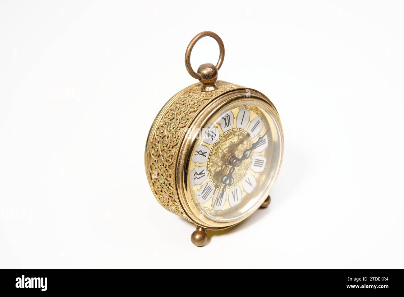 an old golden analog alarm clock with mechanical movement isolated on a ...