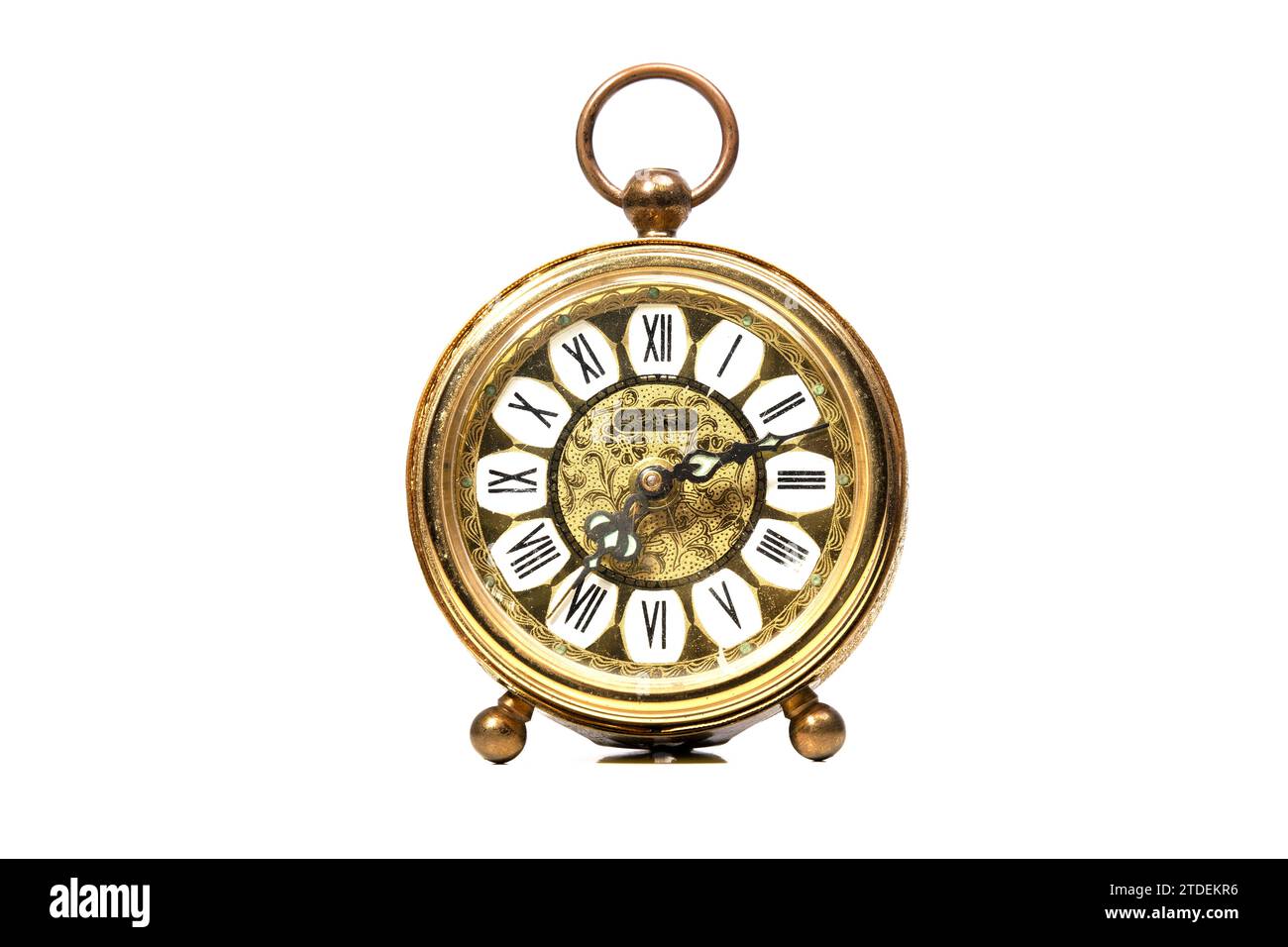an old golden analog alarm clock with mechanical movement isolated on a ...