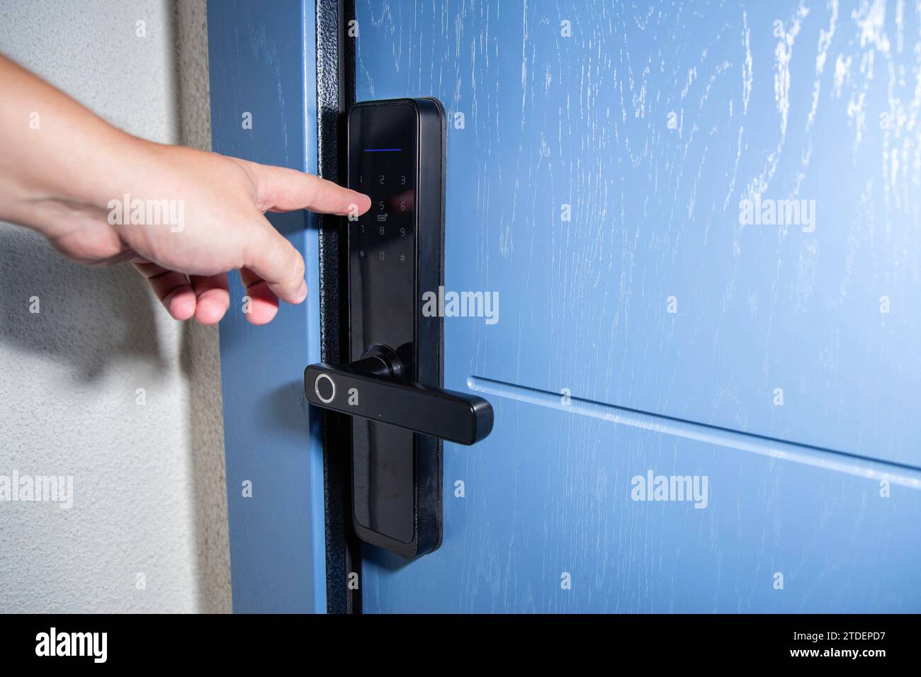 A man opens a door with an electronic lock using an access password ...