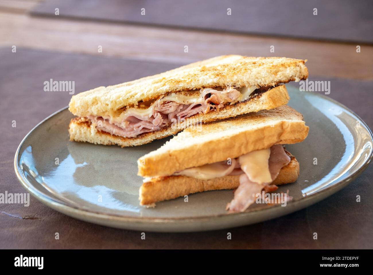 a close up image of a grilled ham and cheese toastie sandwich on a plate Stock Photo - Alamy