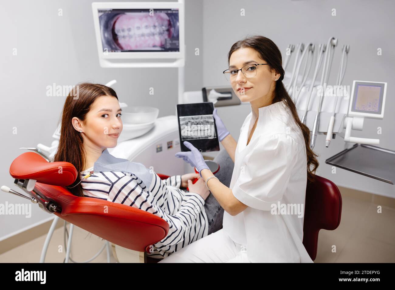 Dentist and patient choosing treatment in a consultation with tablet in ...