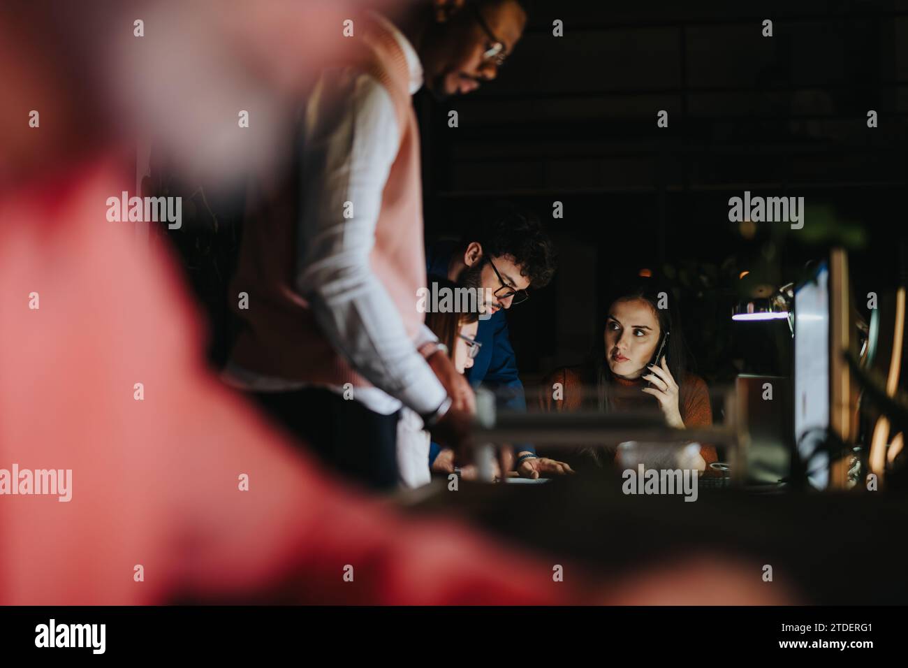 Business professionals working late, analyzing reports, discussing ...